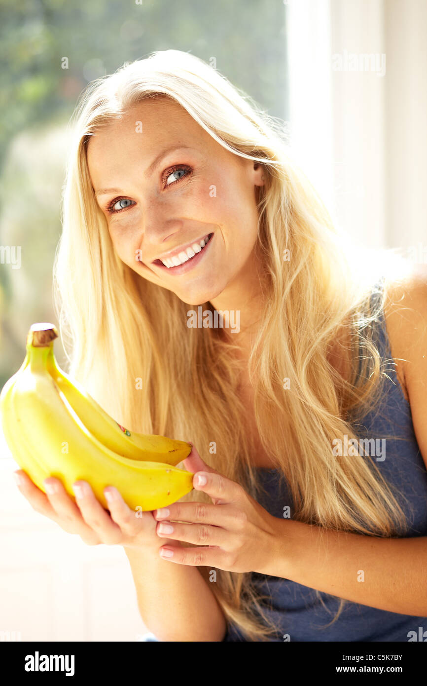 Woman holding bunch of Bananas Stock Photo - Alamy