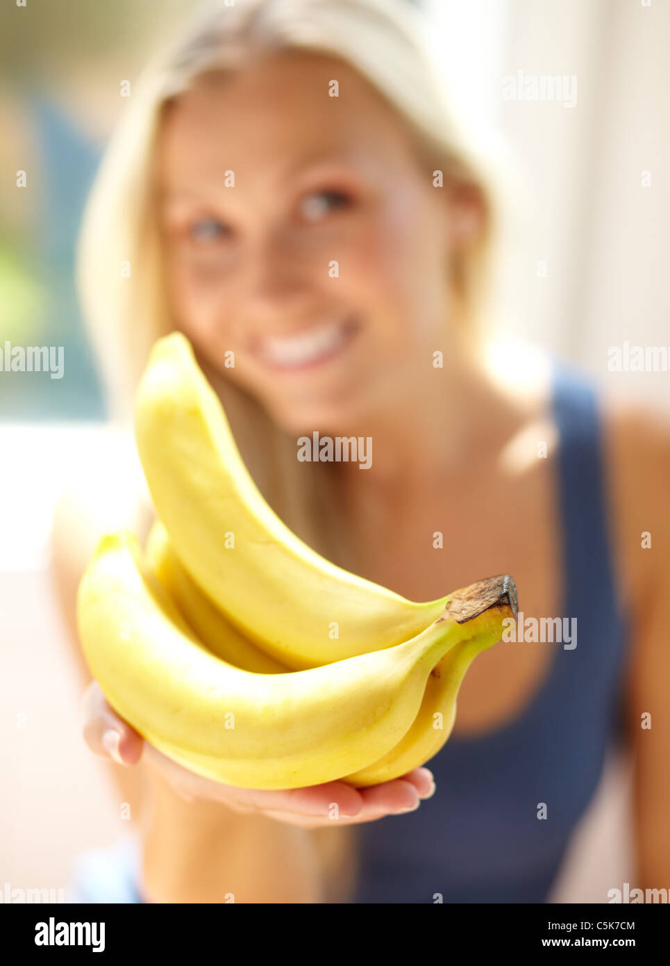 Woman holding bunch of Bananas Stock Photo - Alamy