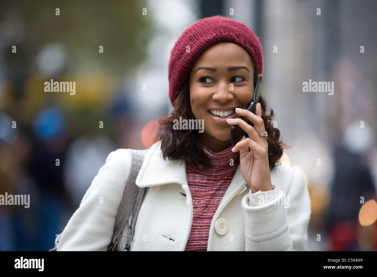 An attractive business woman talks on her cell phone as she walks ...