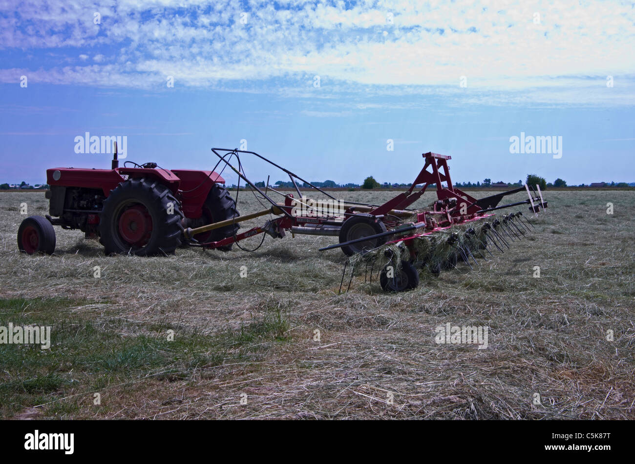 Tractor with hay thrasher Stock Photo - Alamy