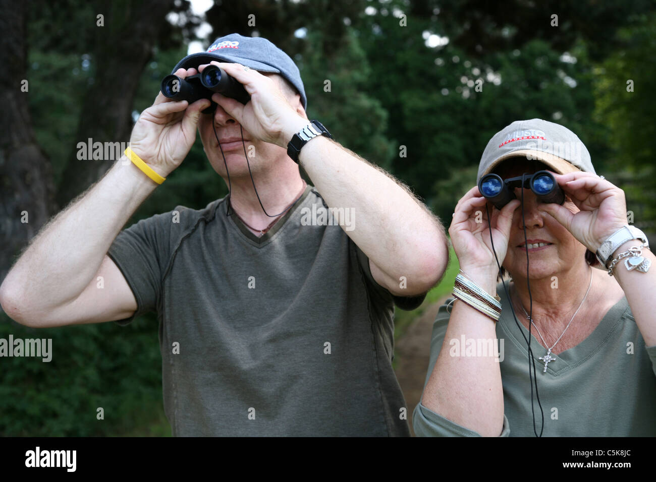 Couple viewing through binoculars outdoors Stock Photo - Alamy