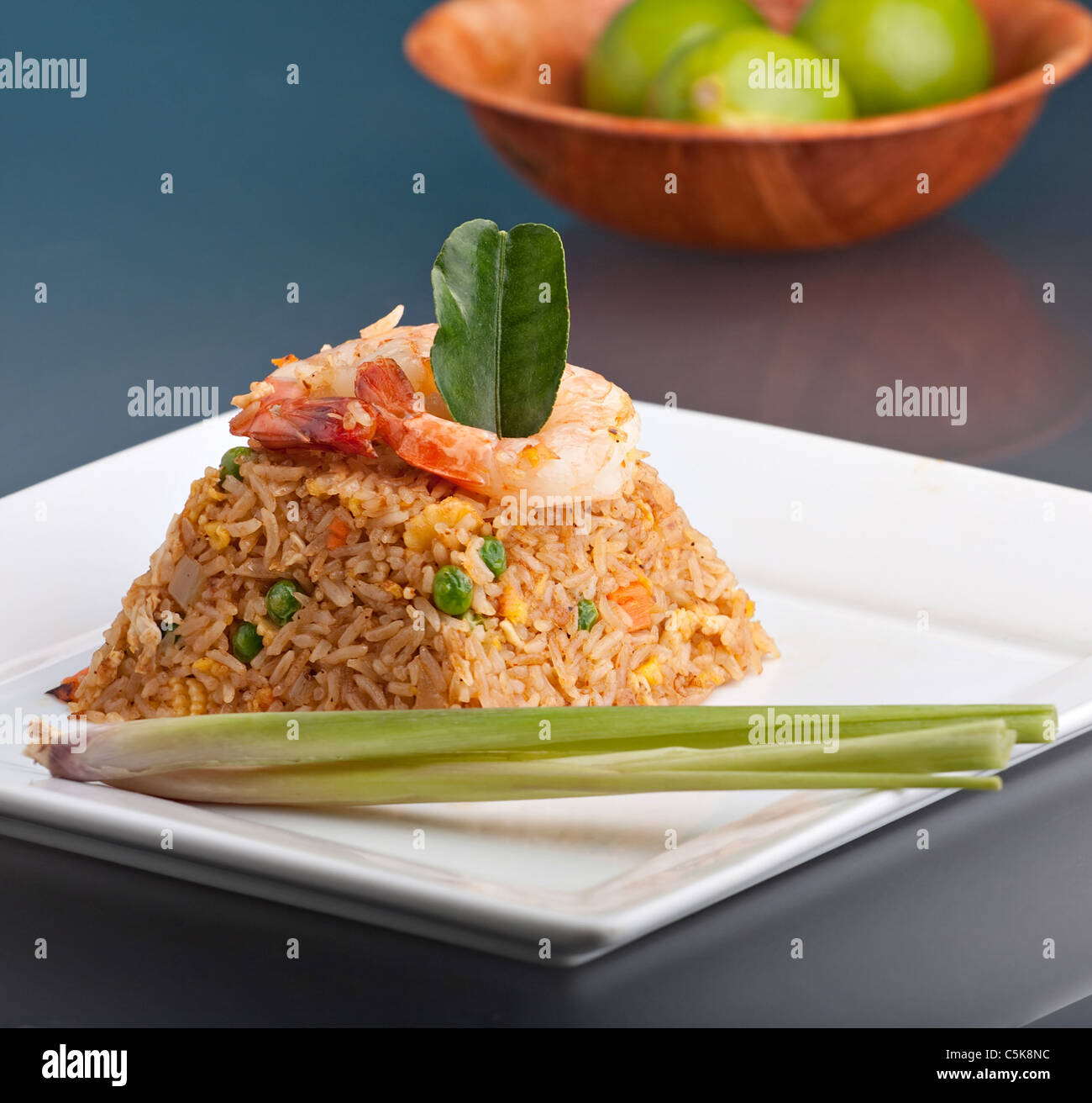 A Thai dish of shrimp fried rice presented on a square white plate in ...