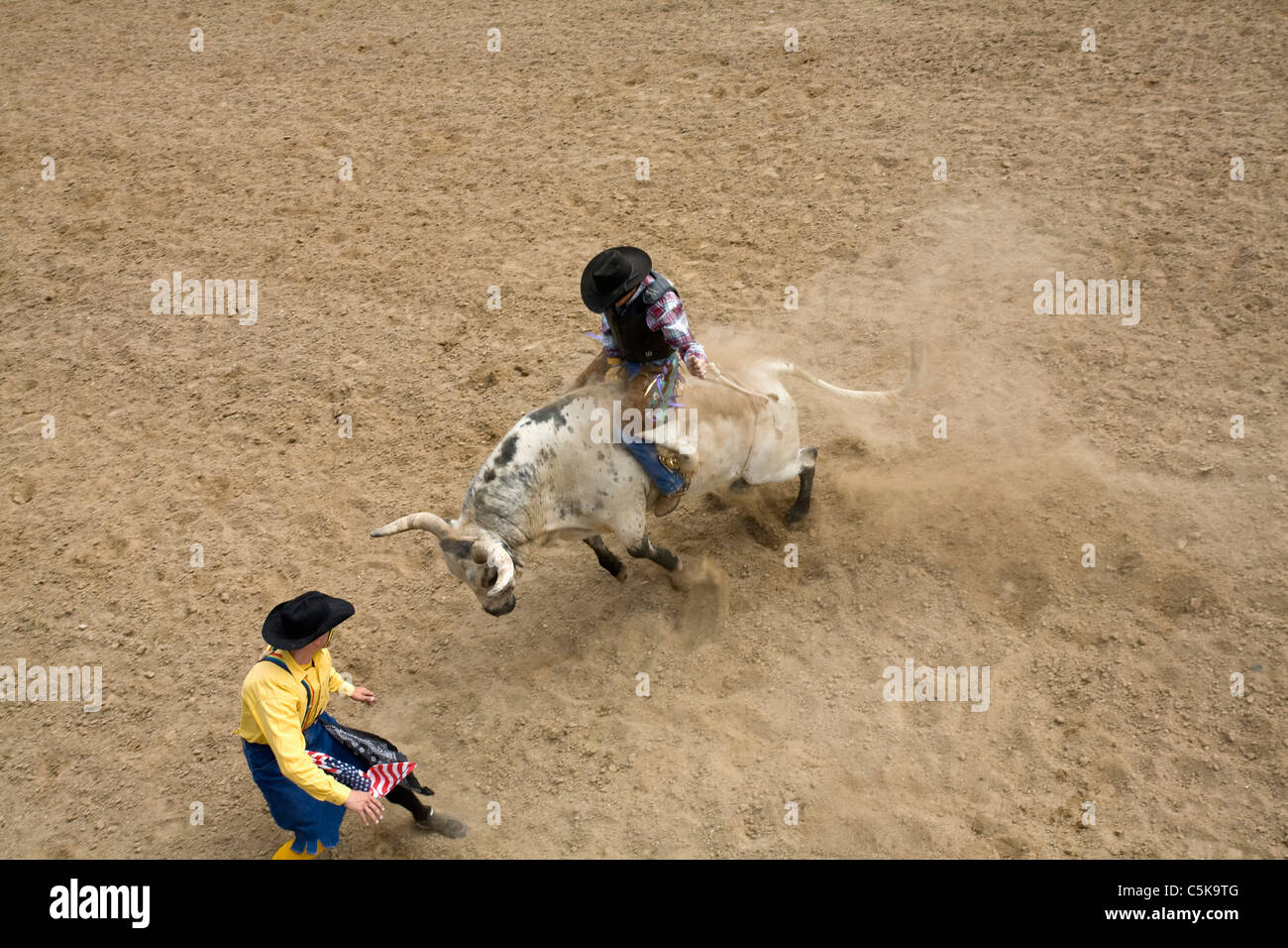 A rodeo clown watches over a bull rider Stock Photo - Alamy