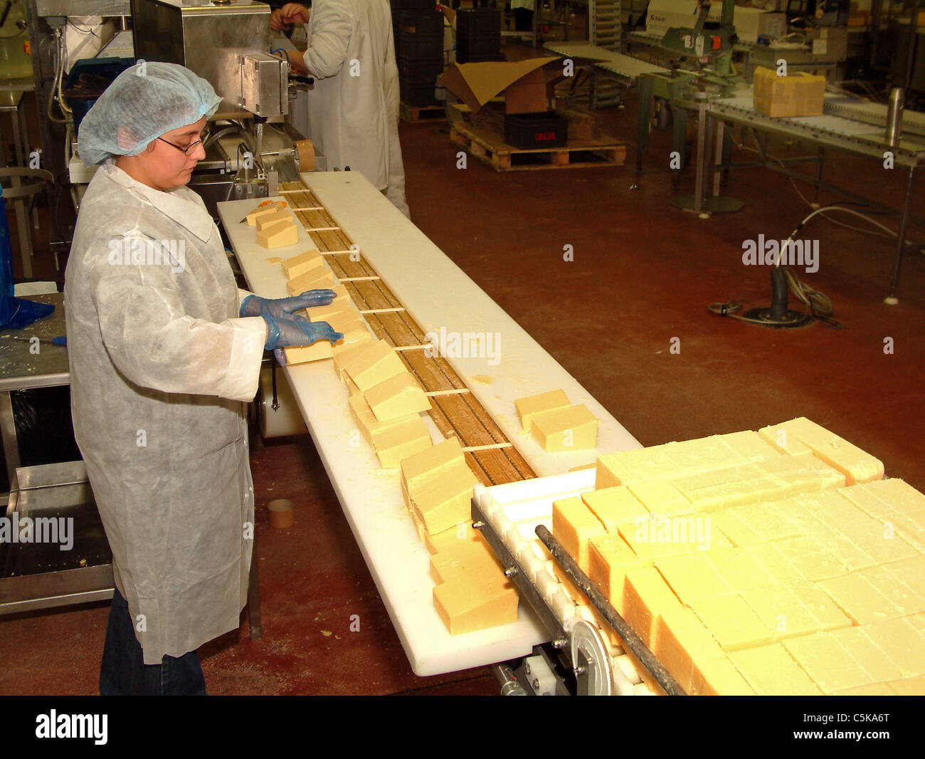 Cutting weighing and Packing individual packs of cheddar cheese at Wyke ...
