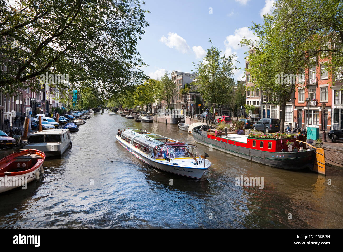 Tourist canal boat sailing along a canal in Amsterdam, Netherlands ...