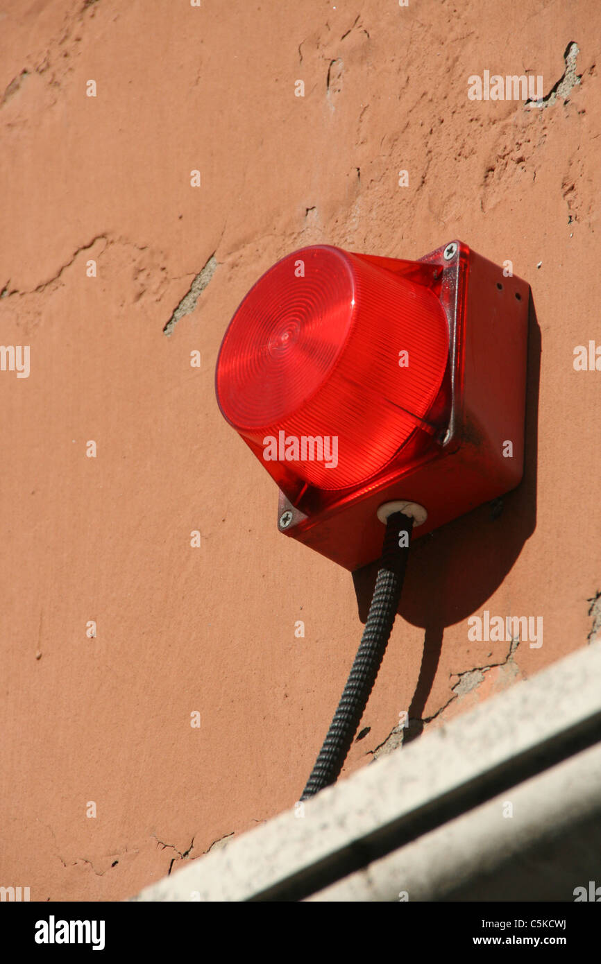 red security light on wall outside building in sun Stock Photo - Alamy