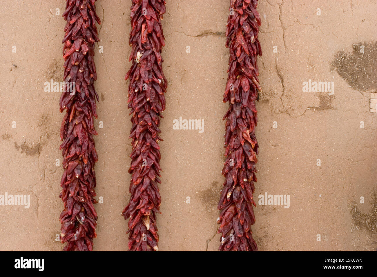 Chili ristras on adobe wall Stock Photo - Alamy