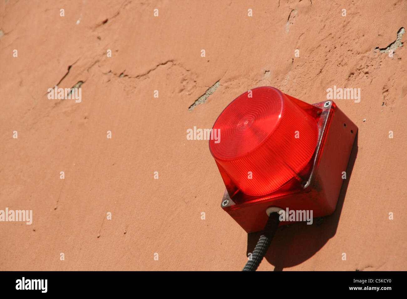 red security light on wall outside building in sun Stock Photo - Alamy