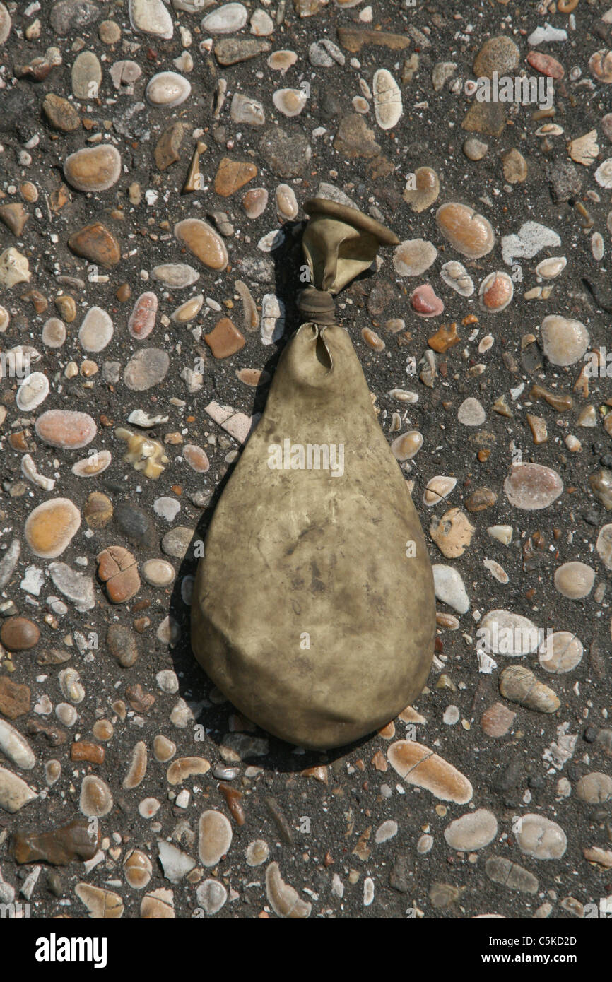close up detail of one burst dirty balloon on floor ground Stock Photo ...