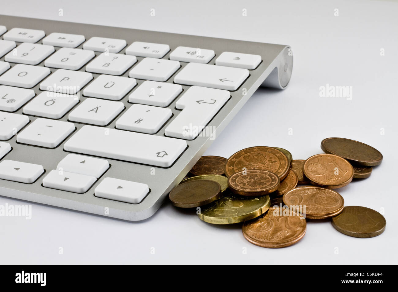 Computer keyboard with white keys and coins Stock Photo - Alamy
