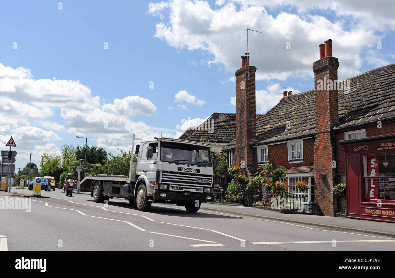 Traffic passing through the small village of Cowfold in west Sussex UK ...