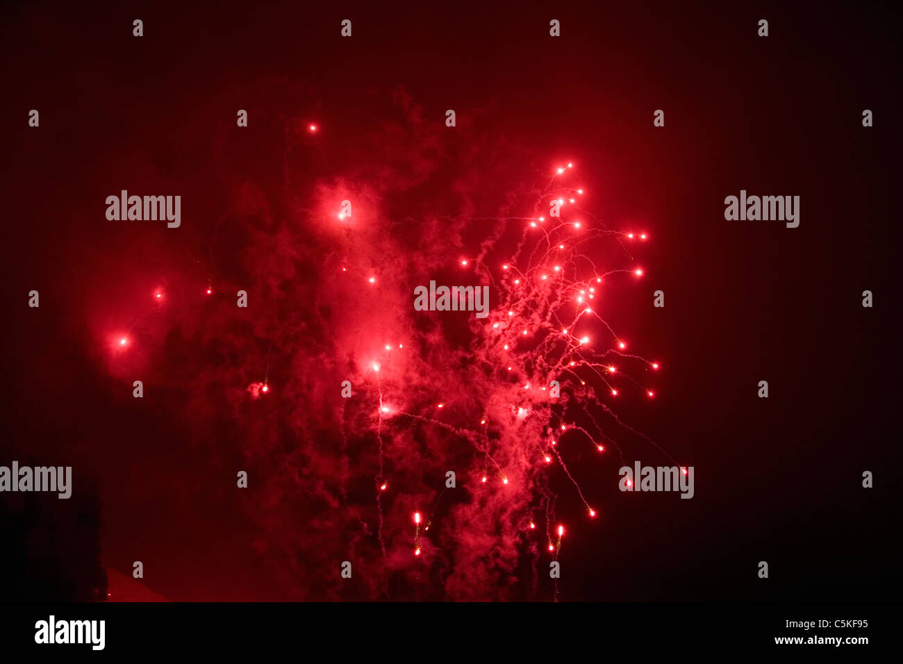 Fireworks explode in red sky Stock Photo - Alamy