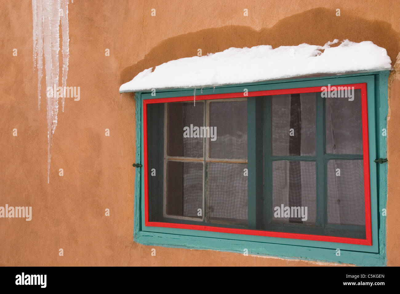 Bright window on adobe house with icicles Stock Photo - Alamy
