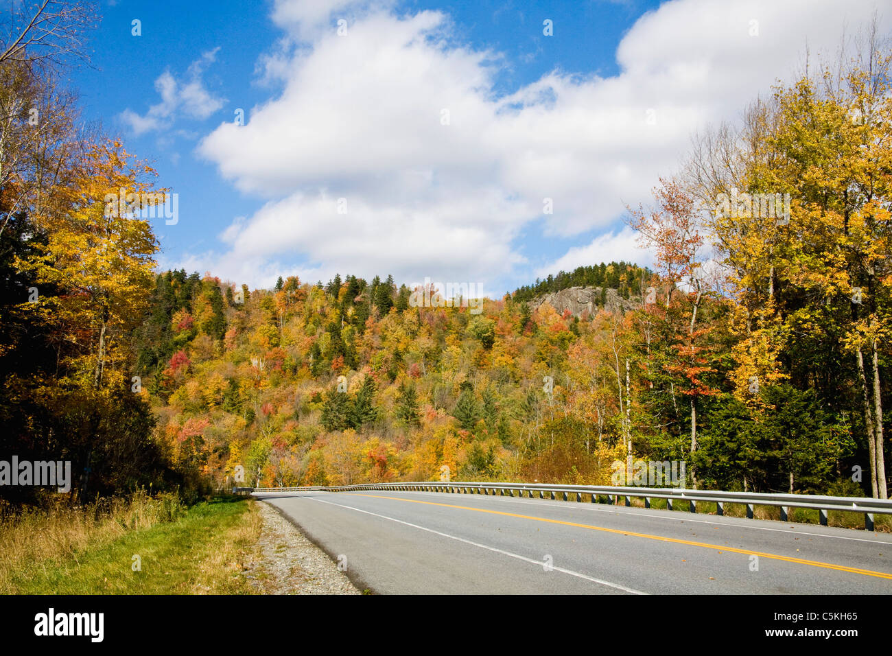Highway with mountain of Fall color trees and blue sky Stock Photo - Alamy