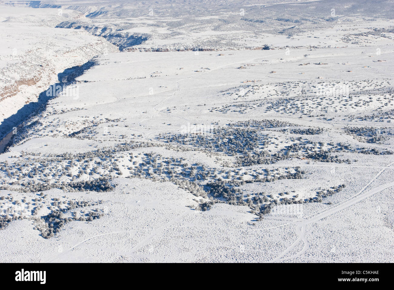 An aerial view of snow covered landscape with trees and river gorge ...