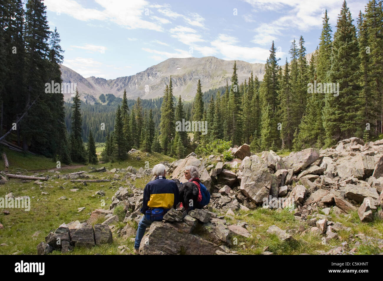 Hikers rest in alpine setting with dog Stock Photo - Alamy