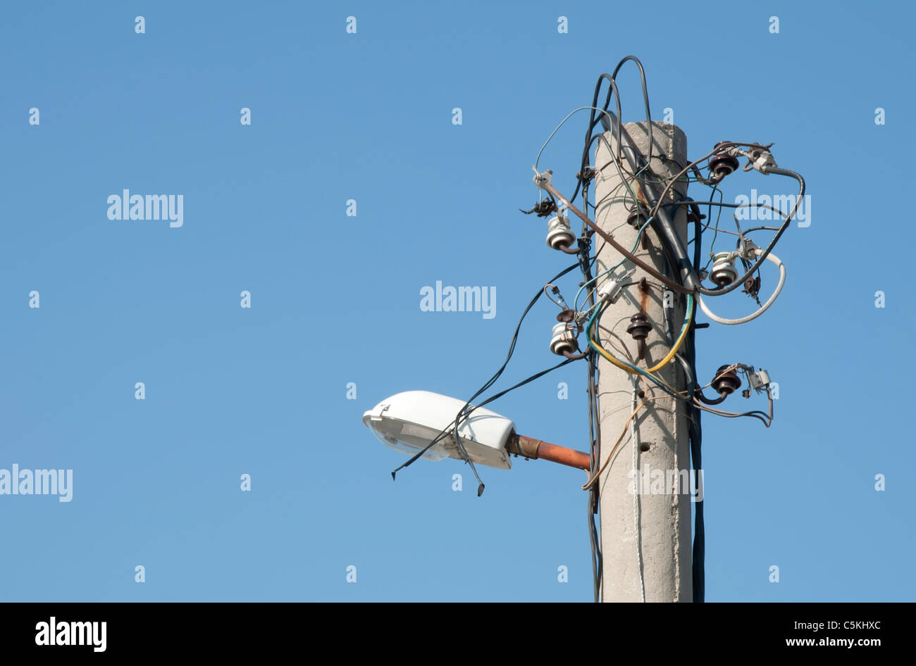 Old electrical wiring. Column on blue sky background Stock Photo - Alamy