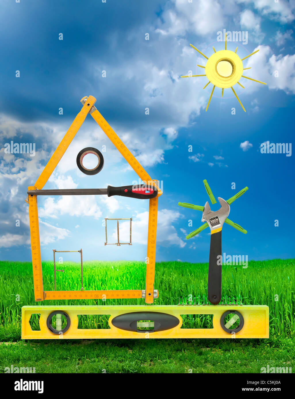 House with tree and sun made of tools for building.Blue sky and grass ...