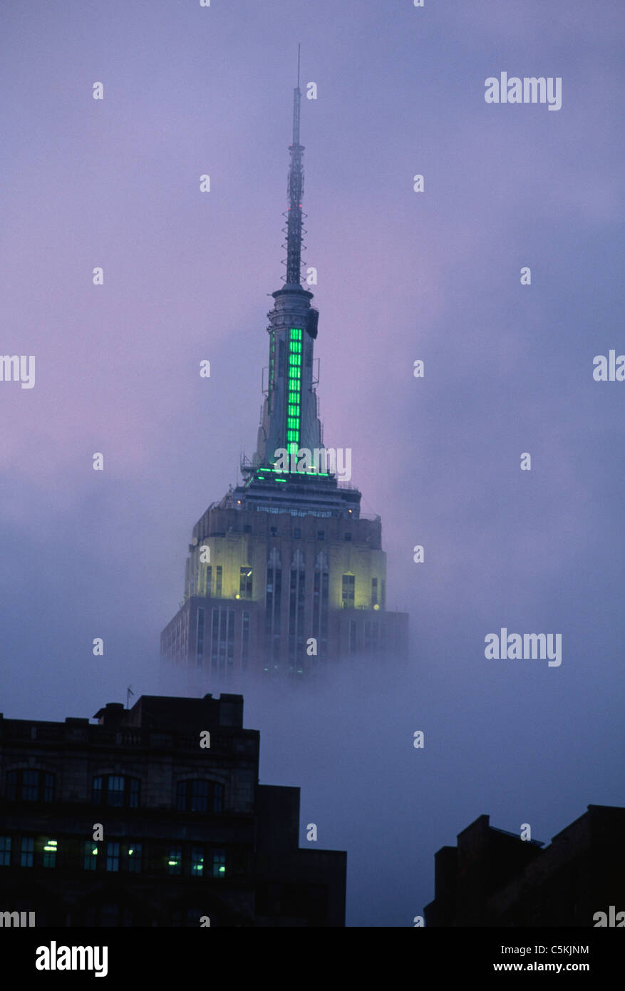 Empire state building tower, partially obscured by clouds, NYC Stock ...