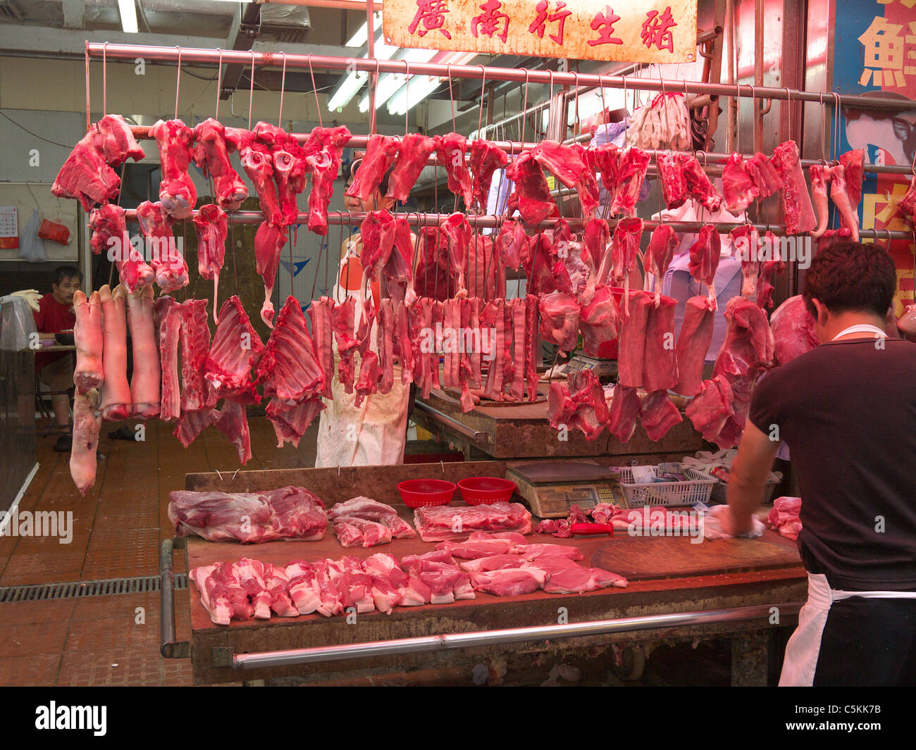 Chinese butcher at work preparing meat for sale at a market in Hong ...