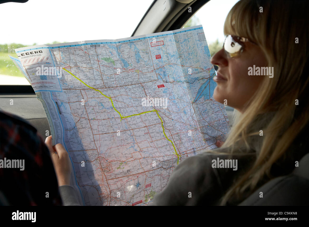 female passenger reading map and giving directions in the usa ...