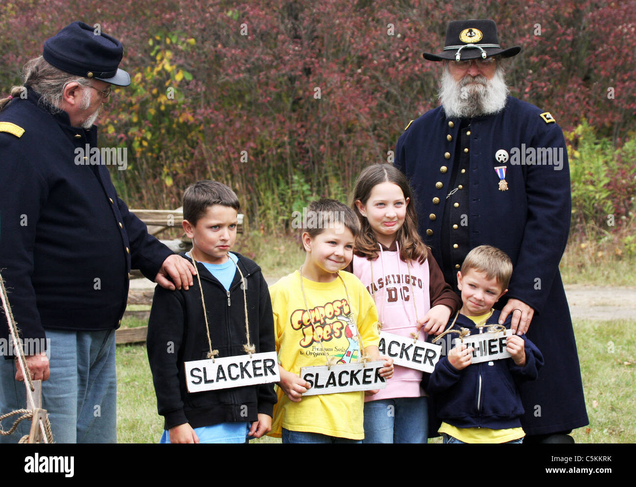Two Union soldiers holding young children under arrest wearing signs of ...