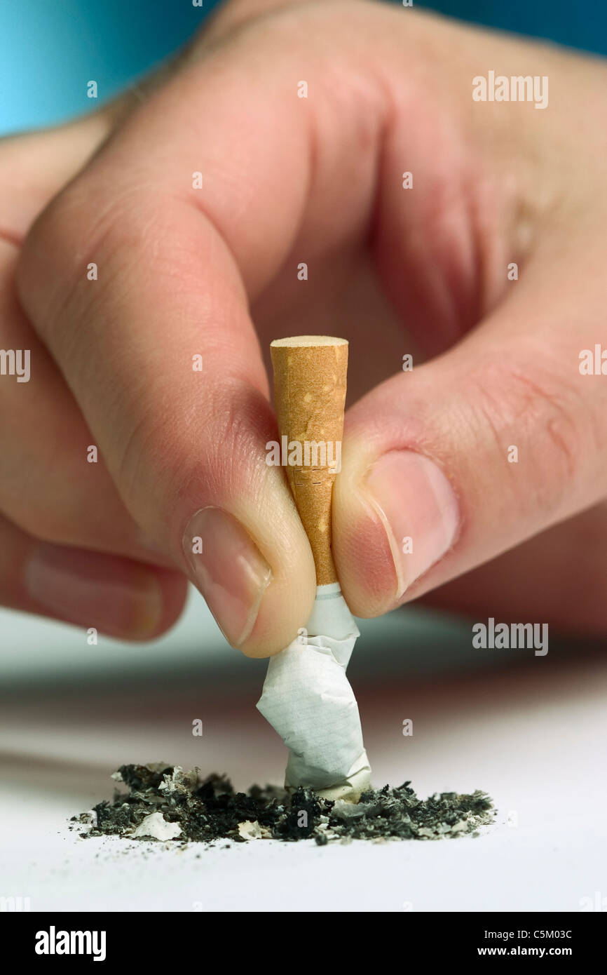 Woman's hand stubbing out a cigarette Stock Photo - Alamy