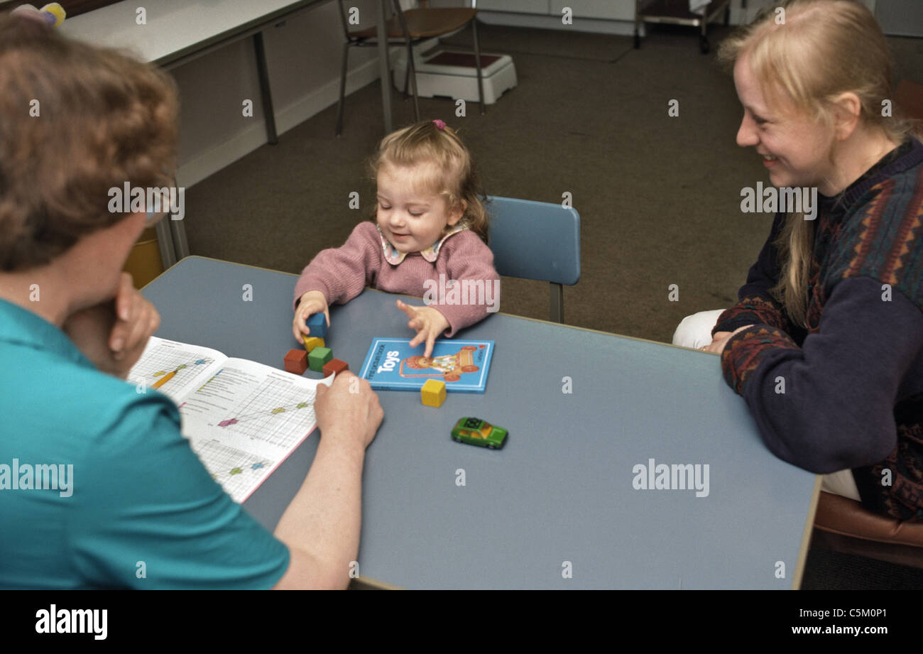 mother with child being tested by health visitor Stock Photo - Alamy