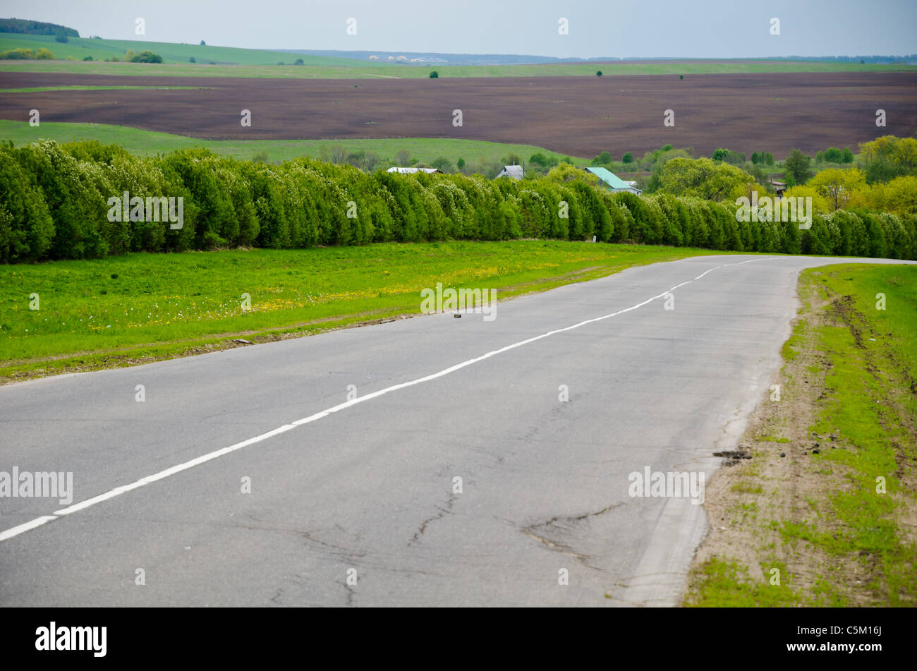 Two-line road bends through the spring countryside Stock Photo - Alamy