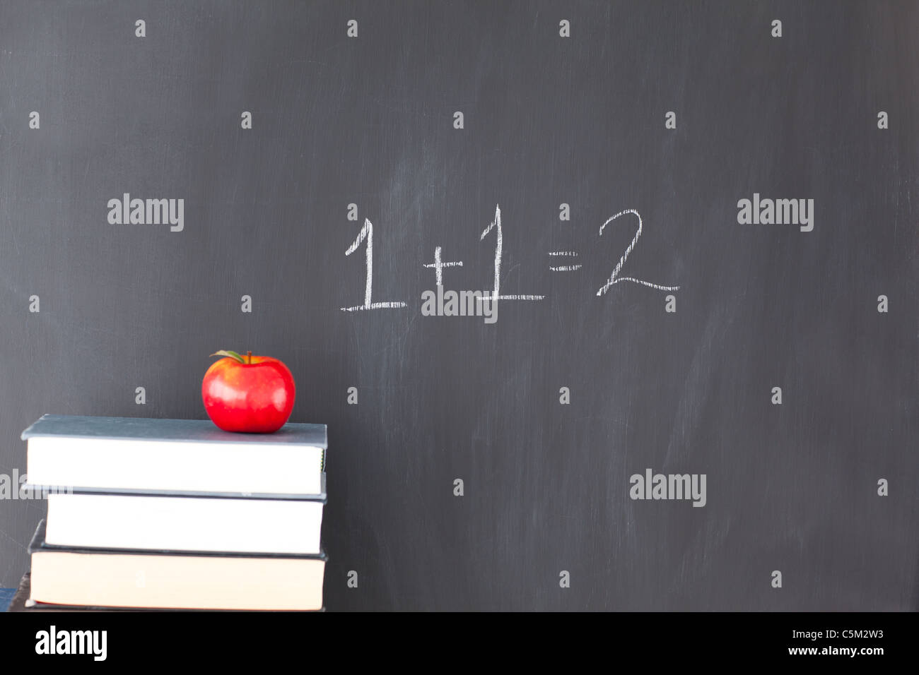Books with an apple and a chalkboard Stock Photo - Alamy