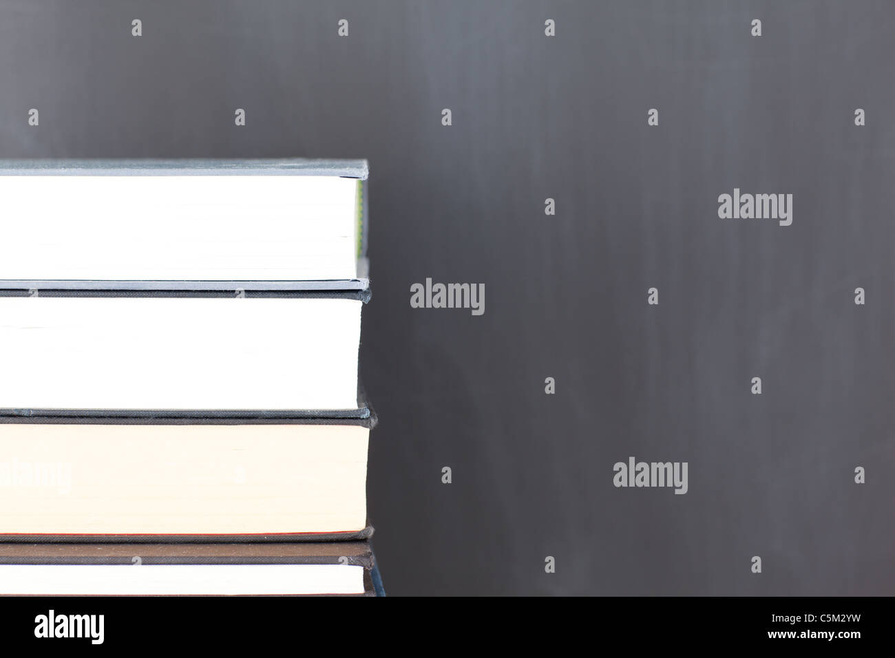 Stack of books and a clean blackboard Stock Photo - Alamy