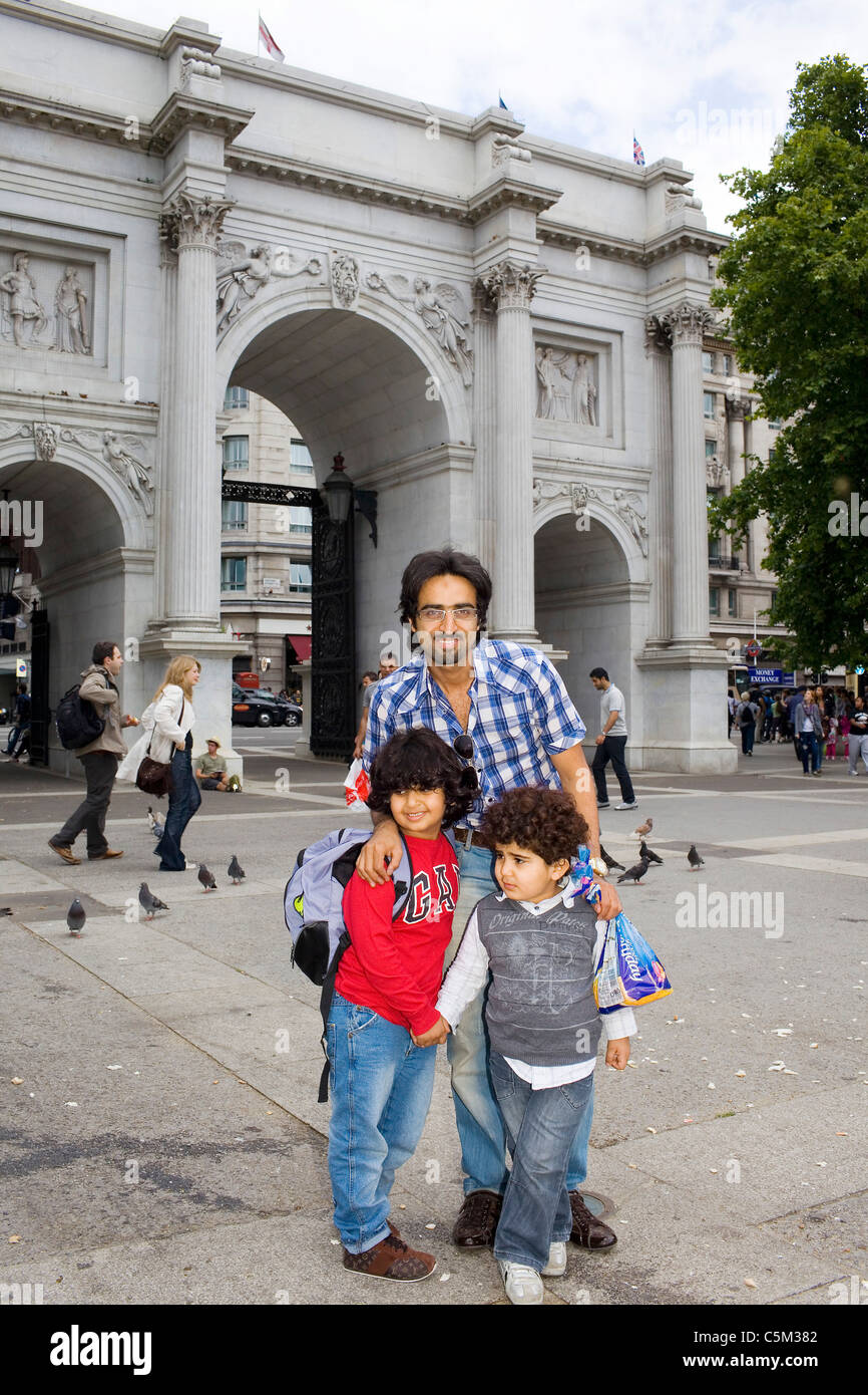 An Arab man with two young boys poses for a photograph in front of ...