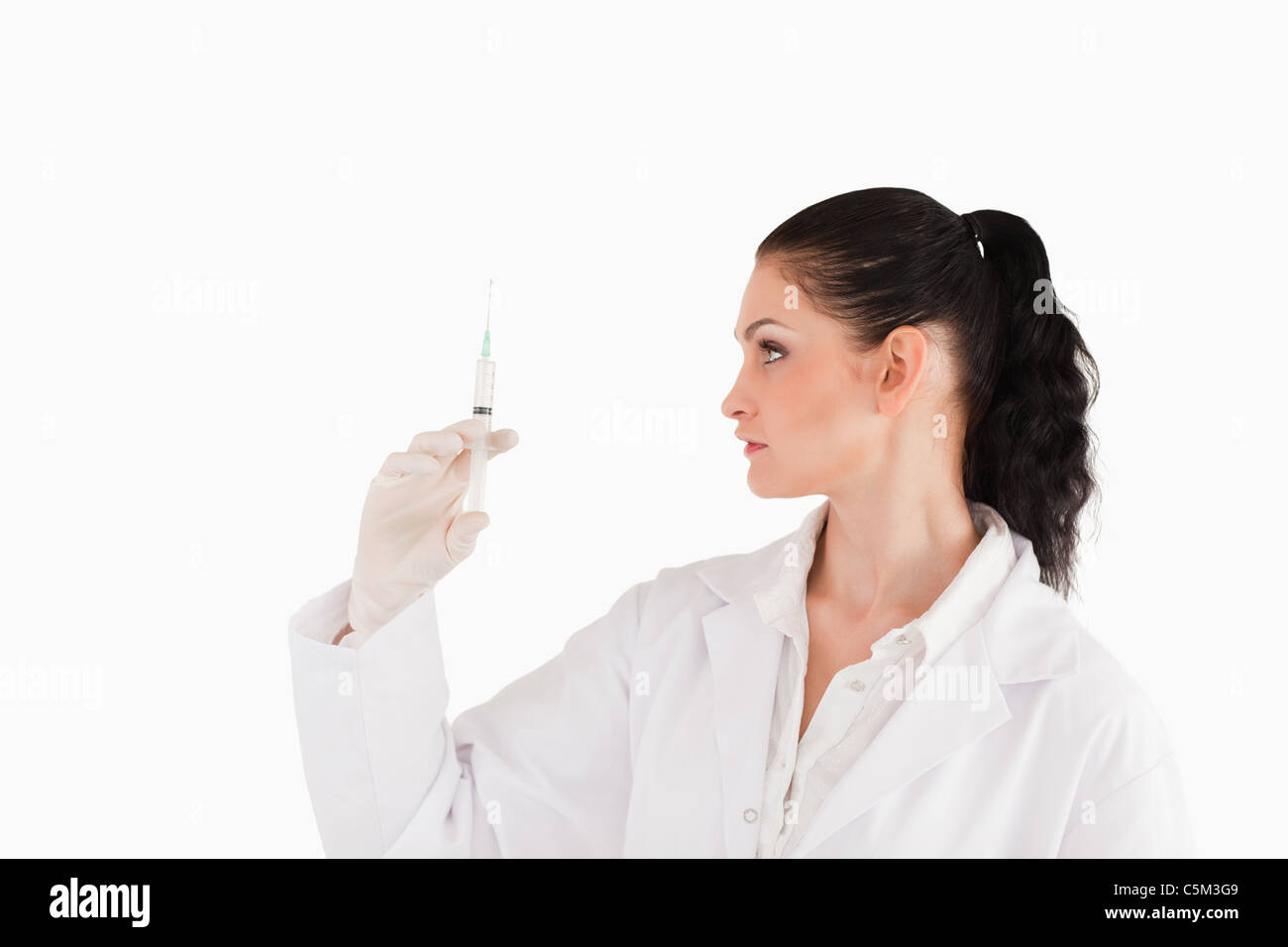 Doctor looking at a syringe Stock Photo - Alamy