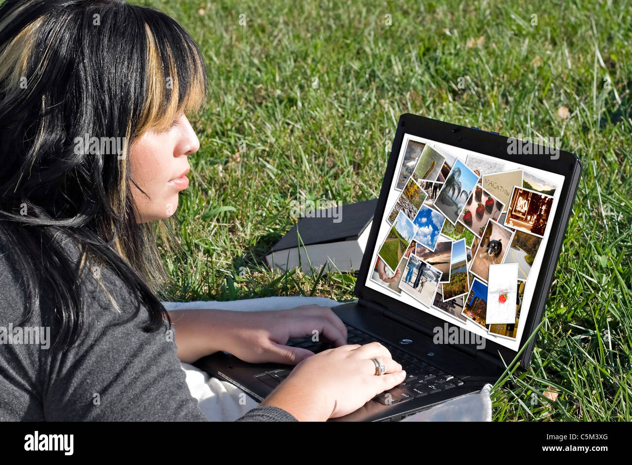 A young woman viewing or editing a gallery of photos on her laptop ...