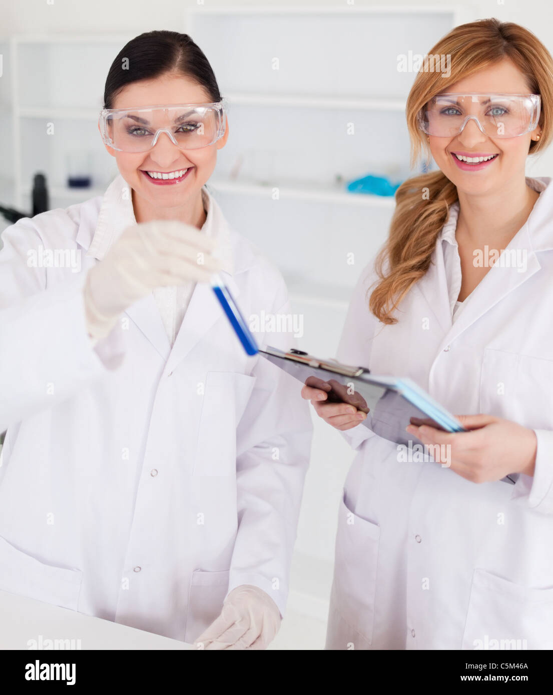 Two scientists posing with a test tube and a notepad Stock Photo - Alamy