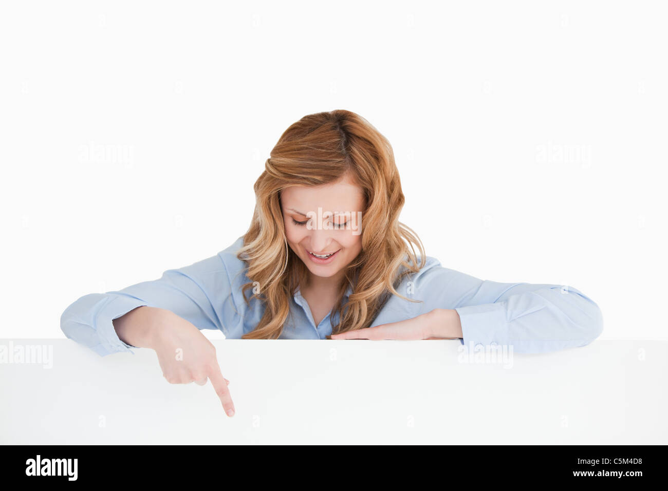 Attractive woman pointing at an empty white board below her Stock Photo ...