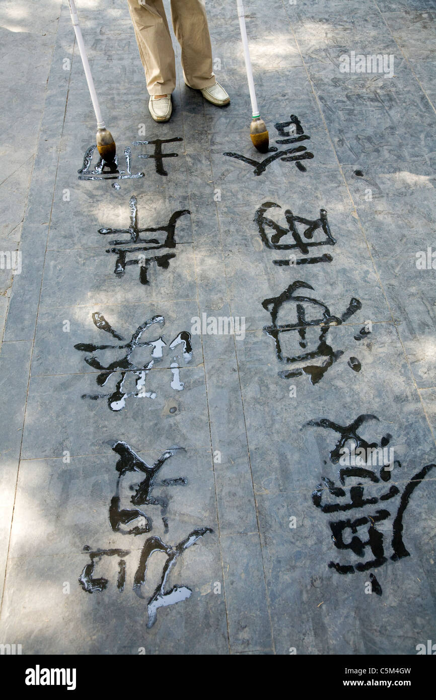 Busker exhibiting the art of calligraphy with water writing of Chinese ...