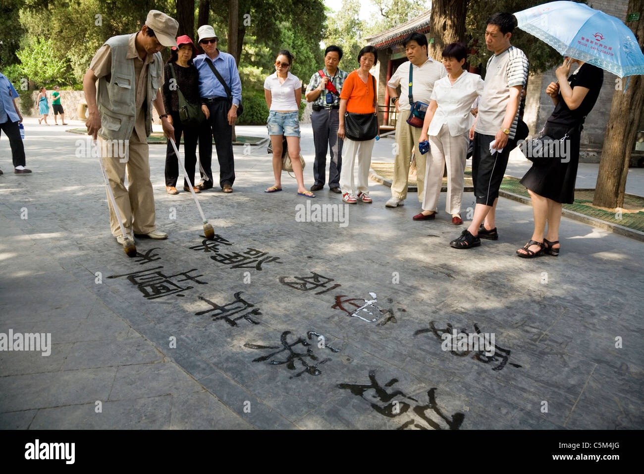 Busker exhibiting the art of calligraphy with water writing of Chinese ...