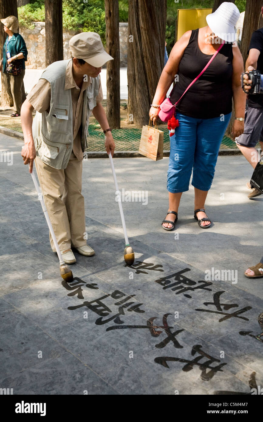 Busker exhibiting the art of calligraphy with water writing of Chinese ...