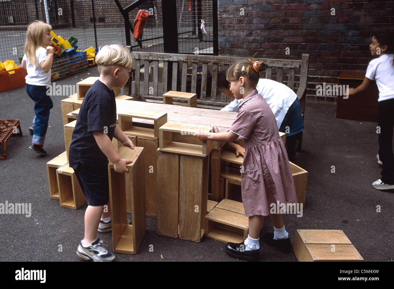 nursery school playground children playing with boxes Stock Photo - Alamy