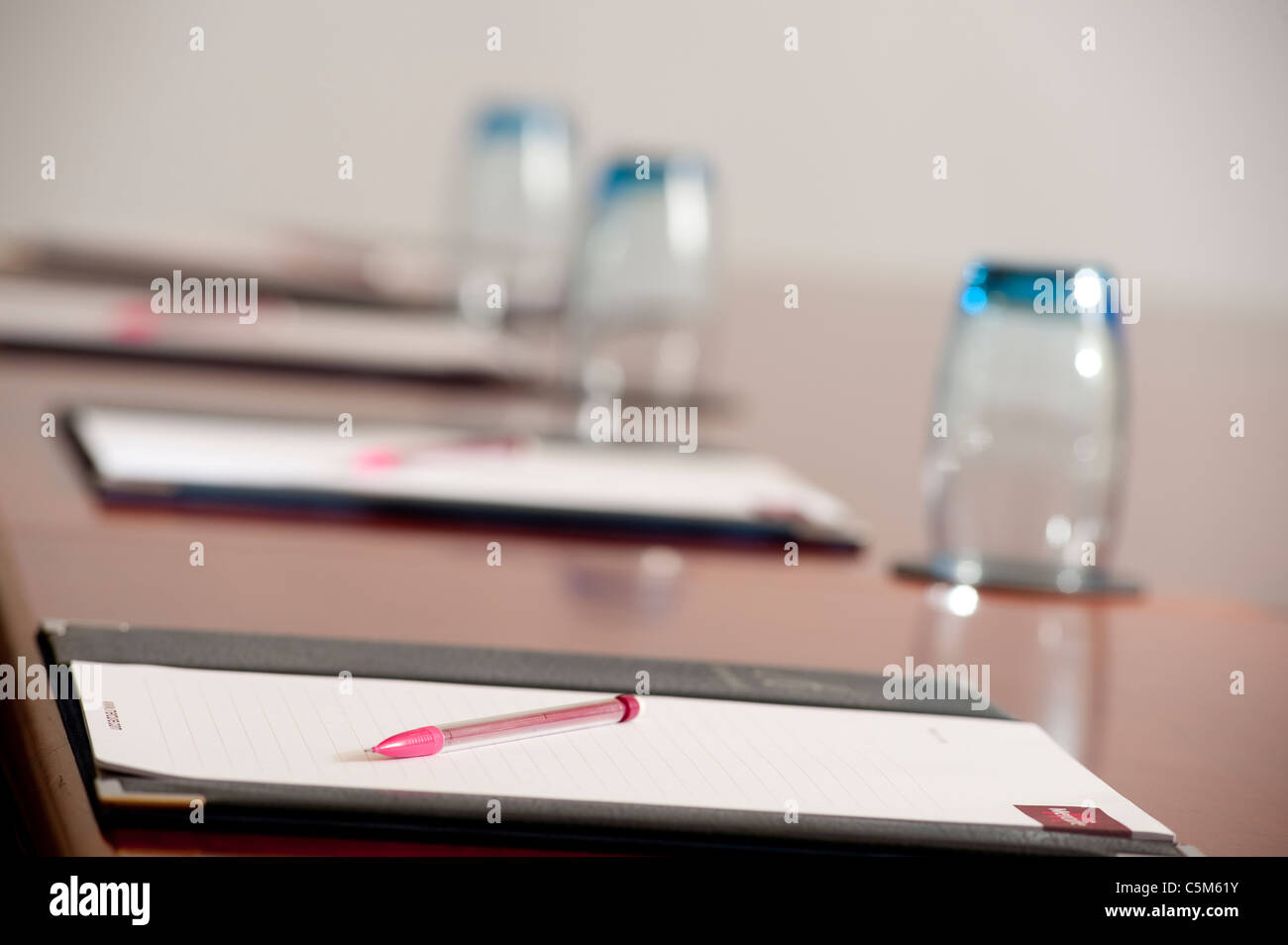 Notepads on a desk in an empty meeting room Stock Photo - Alamy