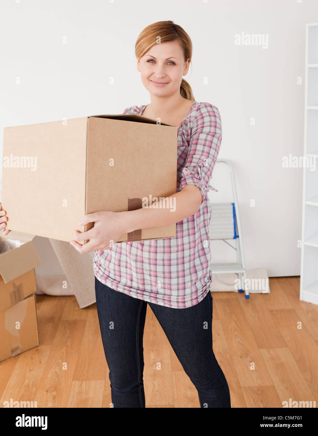 Cute woman carrying cardboard boxes Stock Photo - Alamy