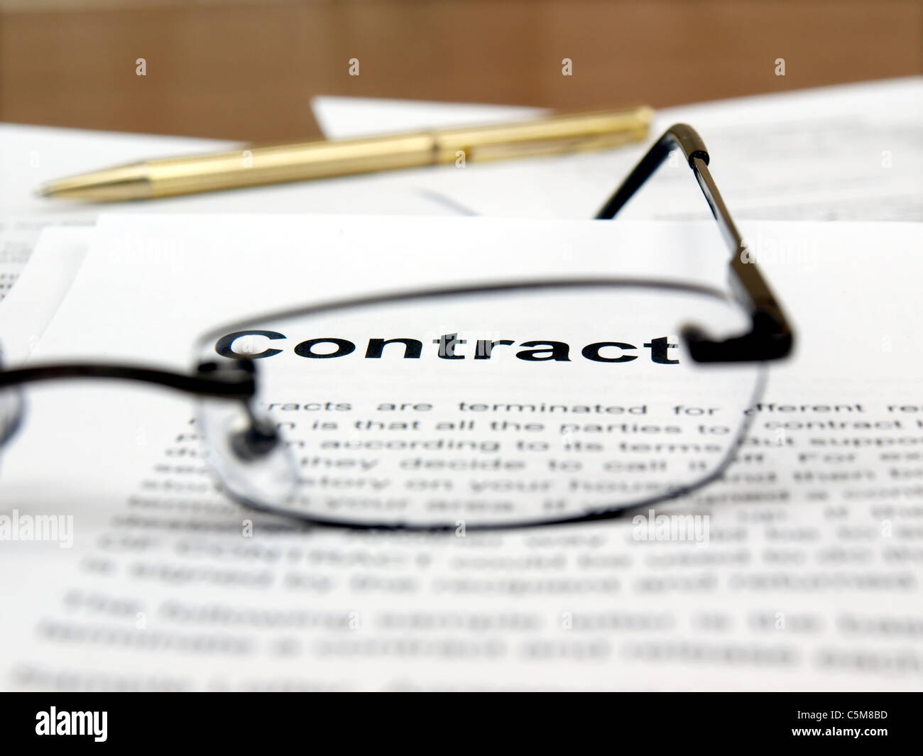 Reading glasses on papers and word "contract"in focus Stock Photo - Alamy
