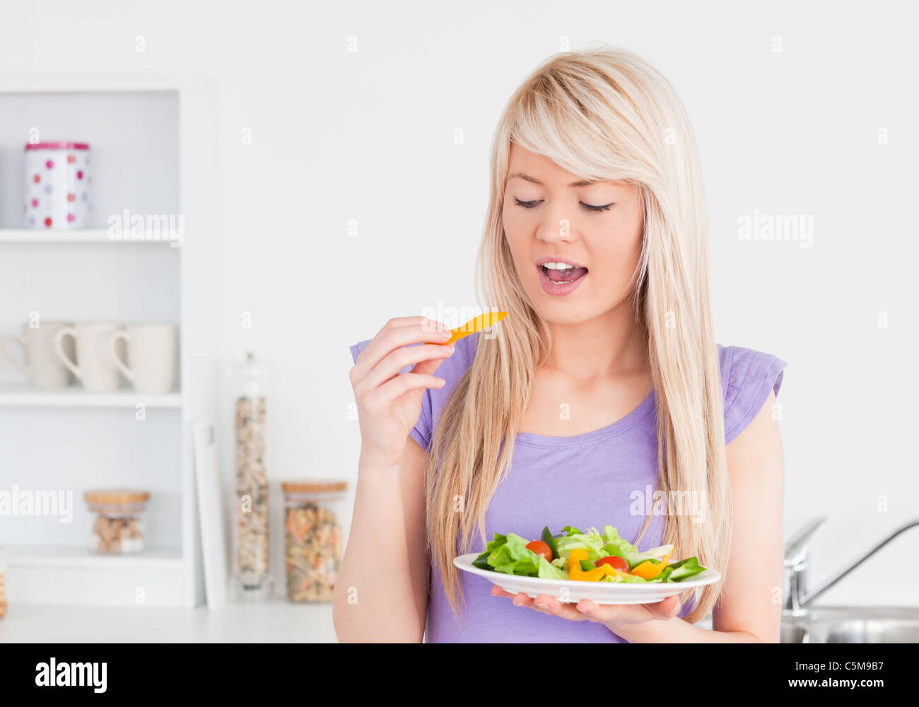 Happy female eating her salad Stock Photo - Alamy