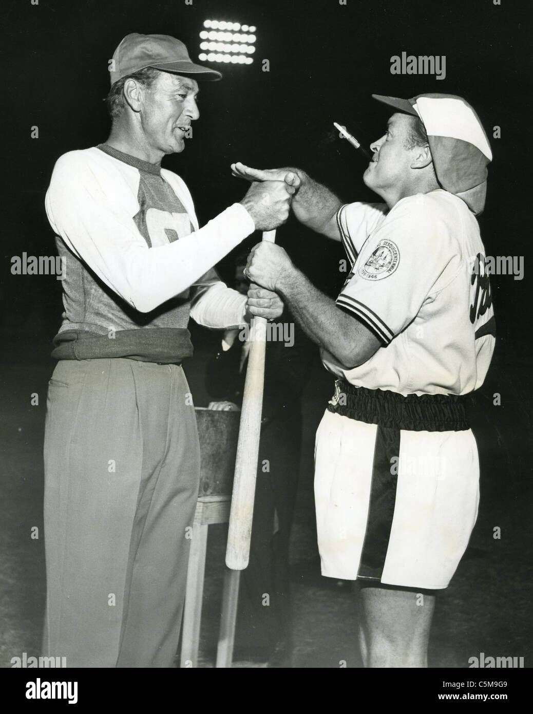 GARY COOPER at left jokes with Bob Hope at a floodlit charity baseball ...