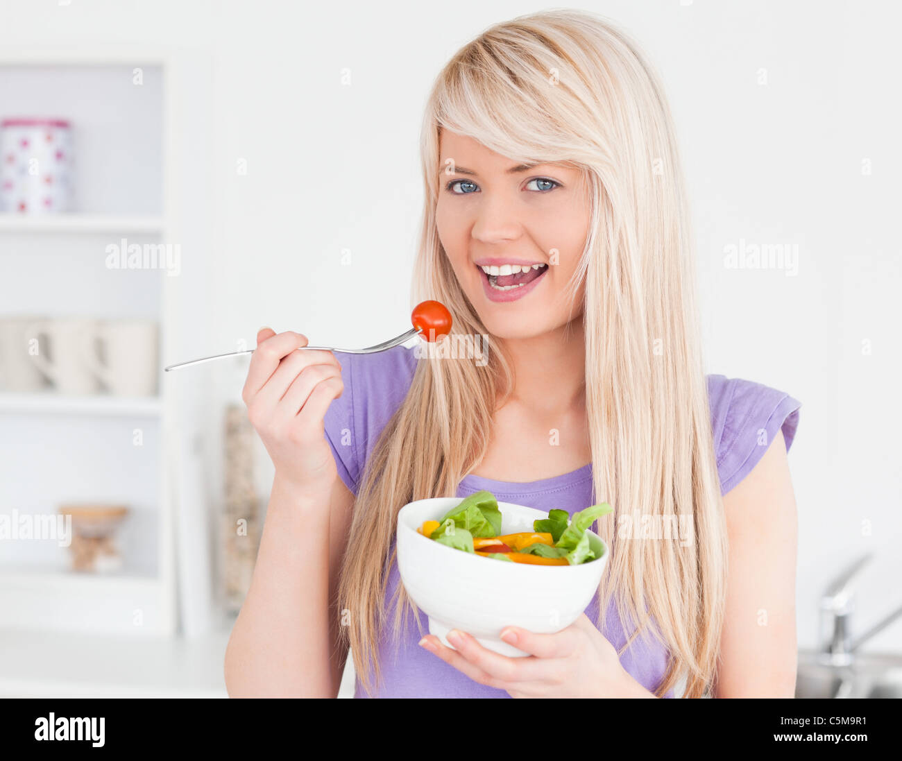 Gorgeous smiling female eating her salad Stock Photo - Alamy