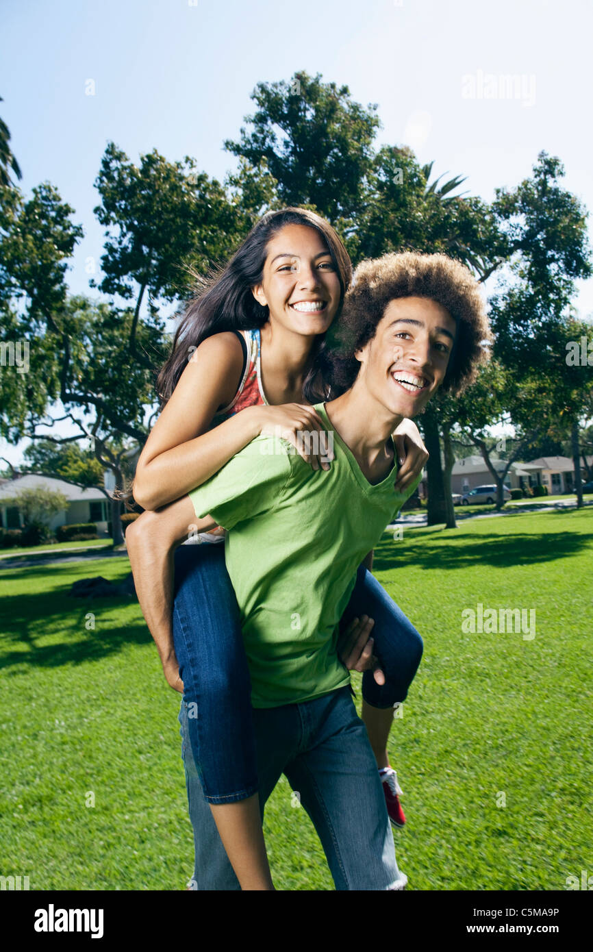Teenager carrying girlfriend on his back in park Stock Photo - Alamy