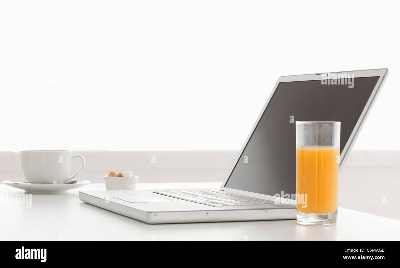 Modern and stylish laptop on a table while breakfast time Stock Photo ...