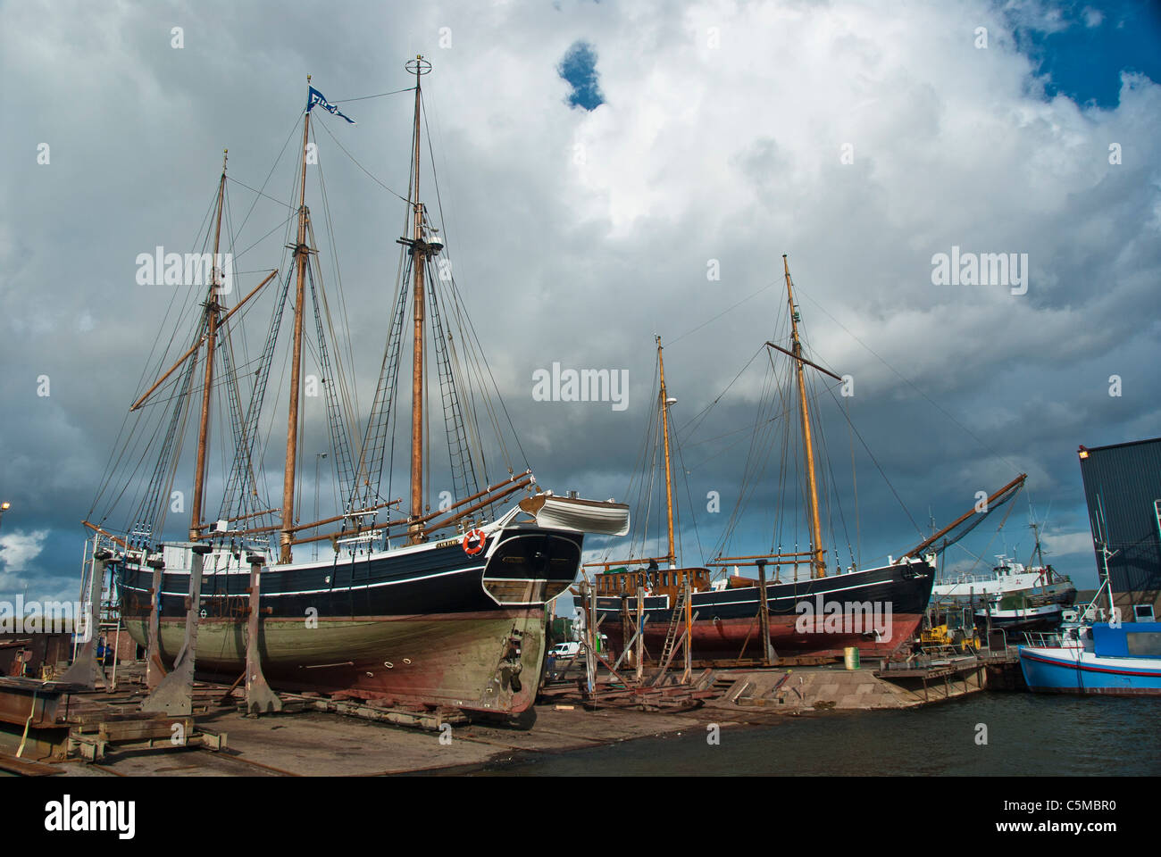 Two old sailing ships are in dry dock, Port of Hvide Sande, Jutland ...