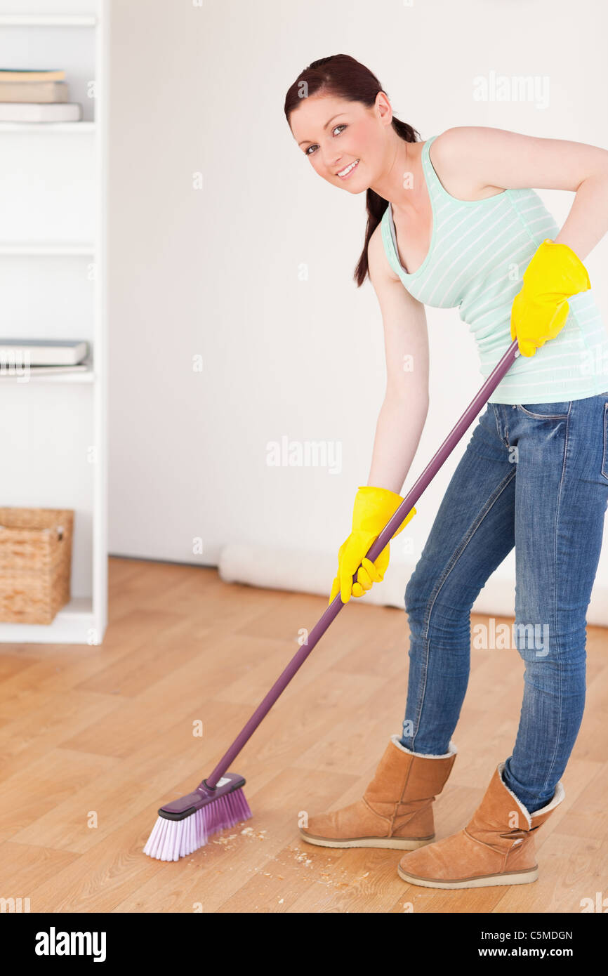 Smiling woman sweeping floor hi-res stock photography and images - Alamy